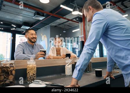Cheerful lady coworkers enjoying coffee break, two businesswomen ...