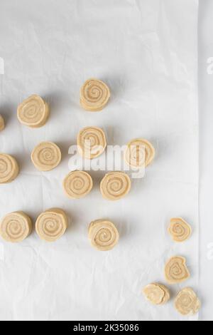 Closeup of raw cinnamon roll and cinnamon buns on baking paper Stock ...