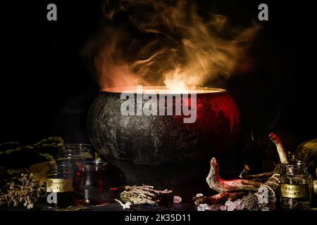 Witch's cauldron with potion and magic attributes for ritual on dark ...