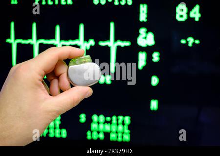 an implantable pacemaker is held in front of an ECG monitor Stock Photo ...