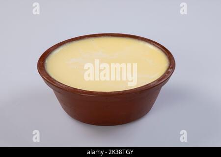 delicious misti doi is a Bengali dessert in a mud pot isolated on white ...
