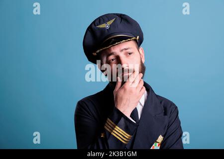 Pensive confused airline pilot in uniform questioning, making decision ...