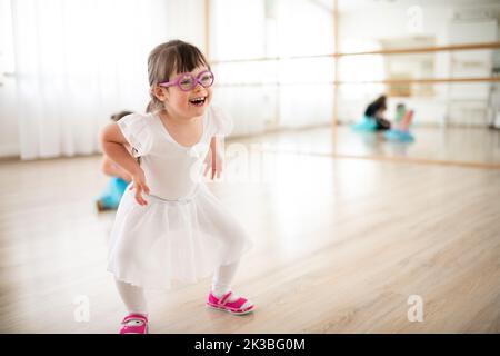 Little girl with down syndrome at ballet class in dance studio ...