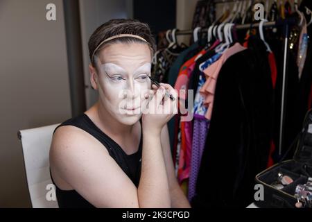 Male drag queen putting on make up and dressing up in prepration for a ...