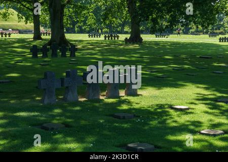 Black crosses of graves under trees at German Military Cemetery and ...