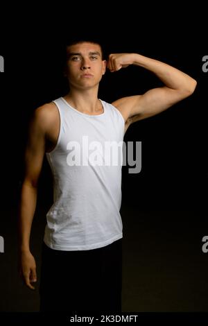Fit and sporty teenage boy flexing both his biceps Stock Photo - Alamy
