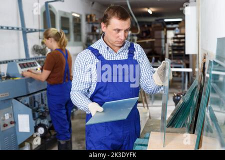 Male glazier working in glass factory Stock Photo - Alamy