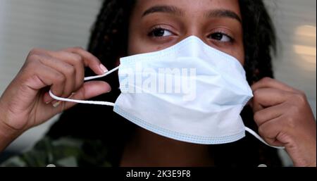 Black preteen girl putting covid-19 face mask prevention Stock Photo ...