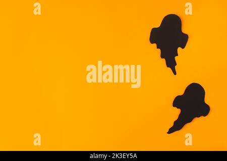 Halloween flat lay. Black ghosts and spiders on orange background ...