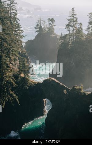 Overlooking an ocean arch in the Pacific Northwest on a warm dreamy day ...