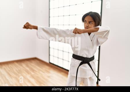 African american girl wearing kimono training karate at sport center ...
