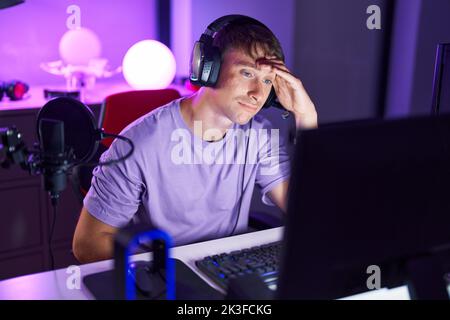 Young caucasian man streamer stressed using computer at gaming room ...