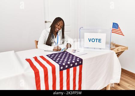 Young african american politic party worker holding badge at electoral ...