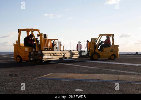 US Navy Weapons Department Sailors man forklifts on the flight deck ...