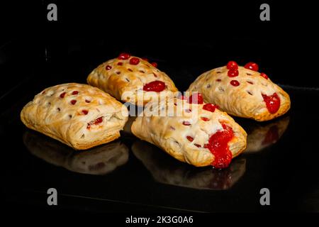 Four baked homemade buns with red strawberry jam in electric oven Stock ...