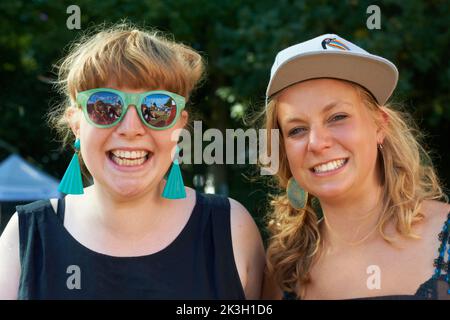 Chilling together at the fest. two young women at an outdoor festival ...