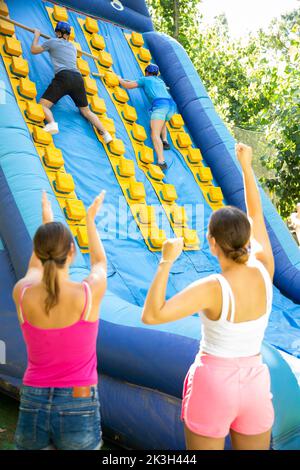 Men climbing up on slide in adventure park Stock Photo - Alamy