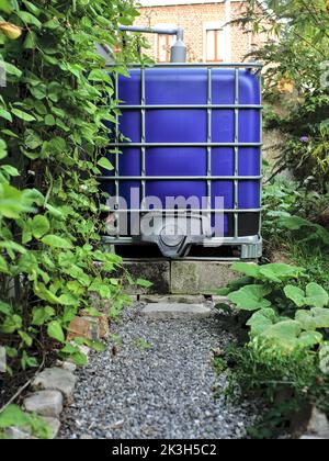 Rainwater collection tank, with blue walls, in a green setting Stock ...