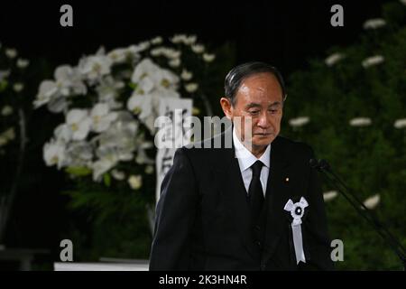 Former Japanese Prime Minister Yoshihide Suga, left, accompanied by his ...