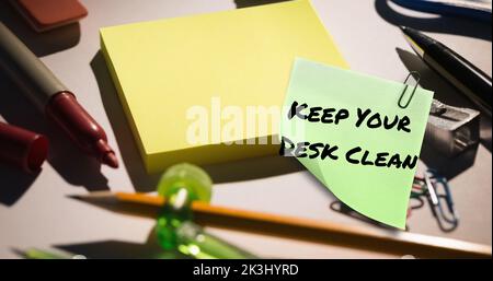 Composite of keep your desk clean text on sticky note with slate and ...