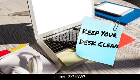 Composite of keep your desk clean text on sticky note with slate and ...