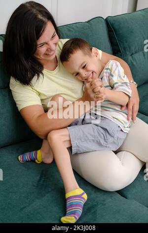 Young disabled boy with cerebral palsy lying on floor mat at home ...