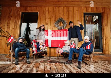 Family with Denmark flags near they wooden house. Travel to ...