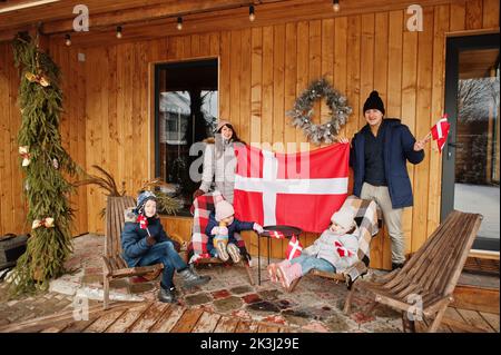 Family with Denmark flags near they wooden house. Travel to ...