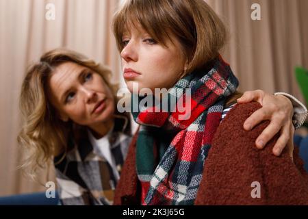 Mother supporting her flu-sick daughter. Woman supports a sad girl ...