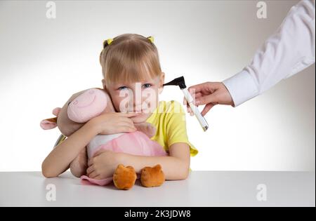 Doctor ENT doctor looks into the ear of a beautiful girl patient at the ...