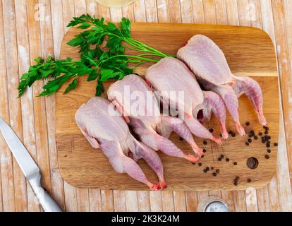 Raw gutted quails and condiments prepared for cooking on wooden table ...