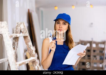 Woman foreman checks the completed construction work on drawing Stock ...