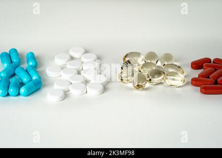 Groups of four kinds of pills on white surface Stock Photo - Alamy