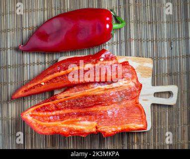 The pulp of long red sweet pepper on the kitchen table. Cut pepper ...