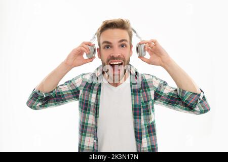 Surprised man taking off headphones for music isolated on white studio ...