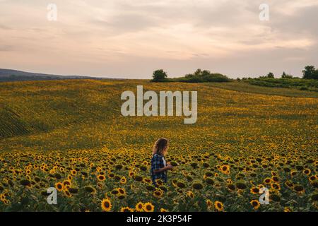 A woman farmer examines with tablet working in vineyard in summer. Copy ...