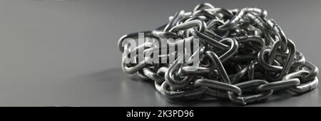 Grey solid chain folded in heap, steel metal iron chain on grey surface ...