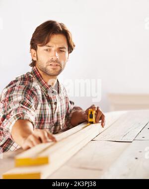 Skilled woodwork. A handyman getting his measurements just perfect with ...