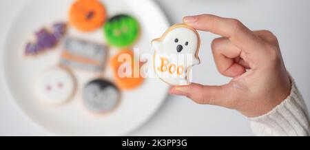 woman hand holding funny Halloween Cookie during drinking coffee. Happy ...