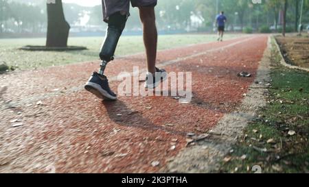 Determined disabled athlete running outside with prosthetic leg ...