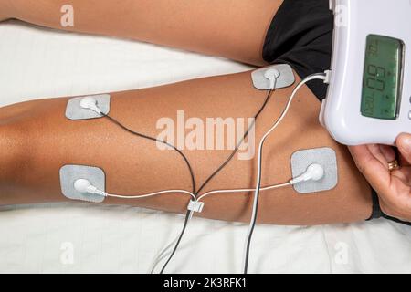 woman in the 40's using TENS (transcutaneous electrical nerve ...