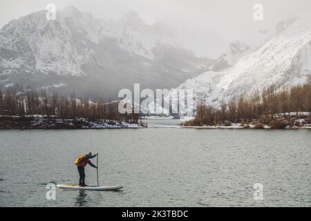 Tourist floating on sup between water surface and picturesque view of ...