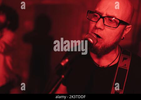 Trendy man singing with a rock band in red light at studio Stock Photo ...