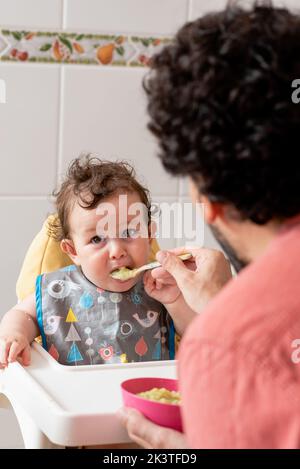 Young toddler in high chair eating messily Stock Photo - Alamy