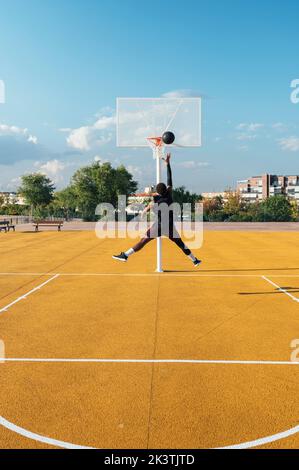 Back view of powerful energetic African American sportsman hanging on ...