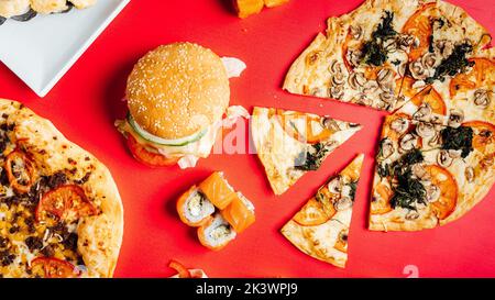 A top view of fast food delicacies including pizza, burger and sushi ...