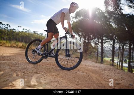 Nothing beats an extreme bike ride. Fit cyclist riding across rough ...