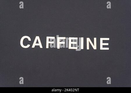 CAFFEINE word written on dark paper background. CAFFEINE text on dark ...