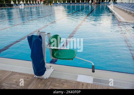Swinging arm disabled chair. Swimming pool lift with a chair Stock ...
