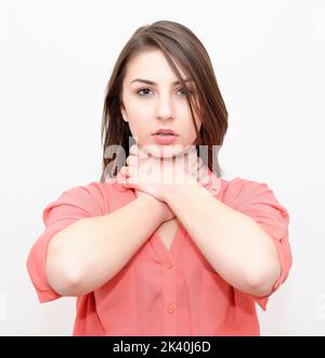 Portrait of young woman choking her neck on black background ...